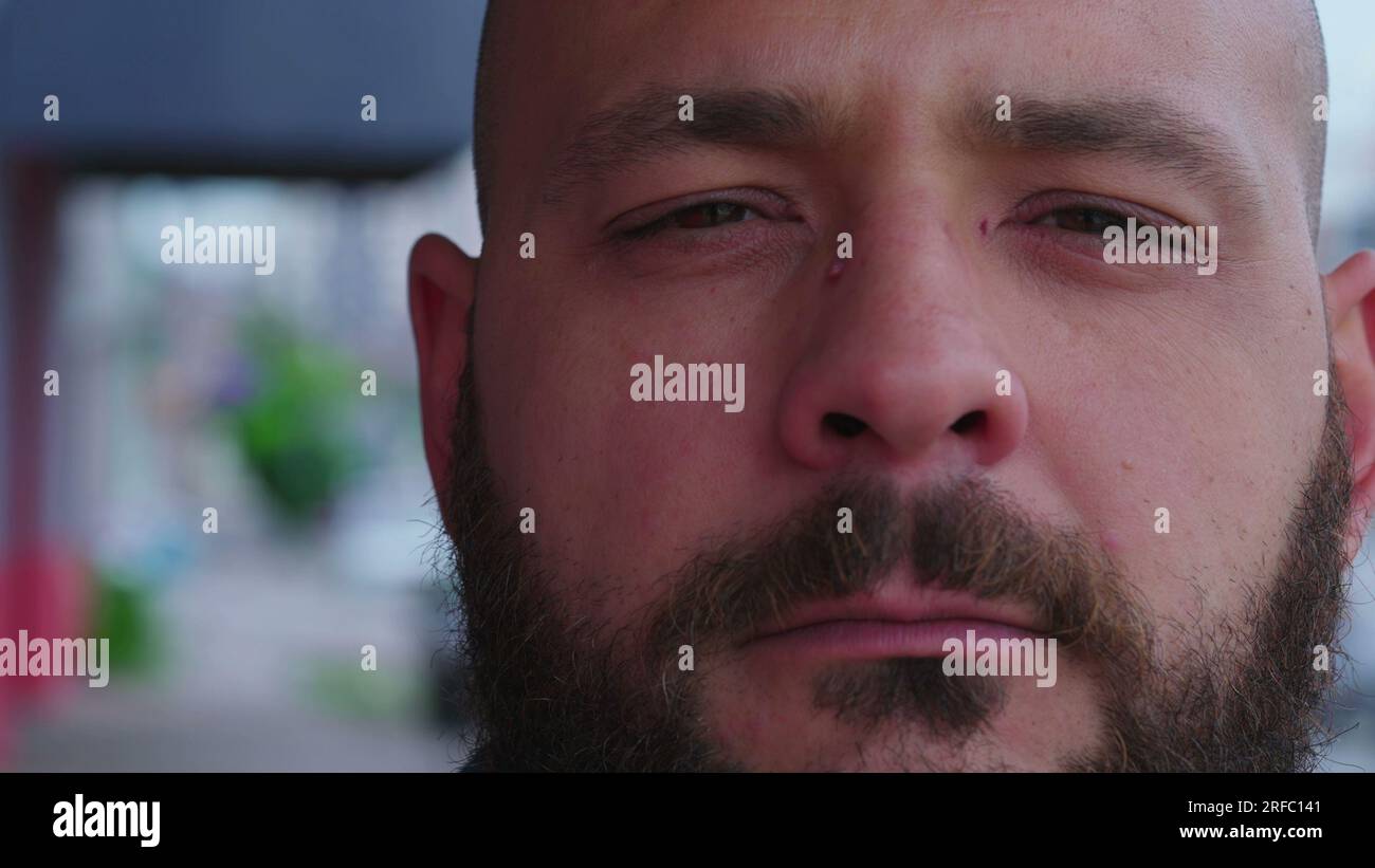 One serious bearded male person with stern serious expression staring ...