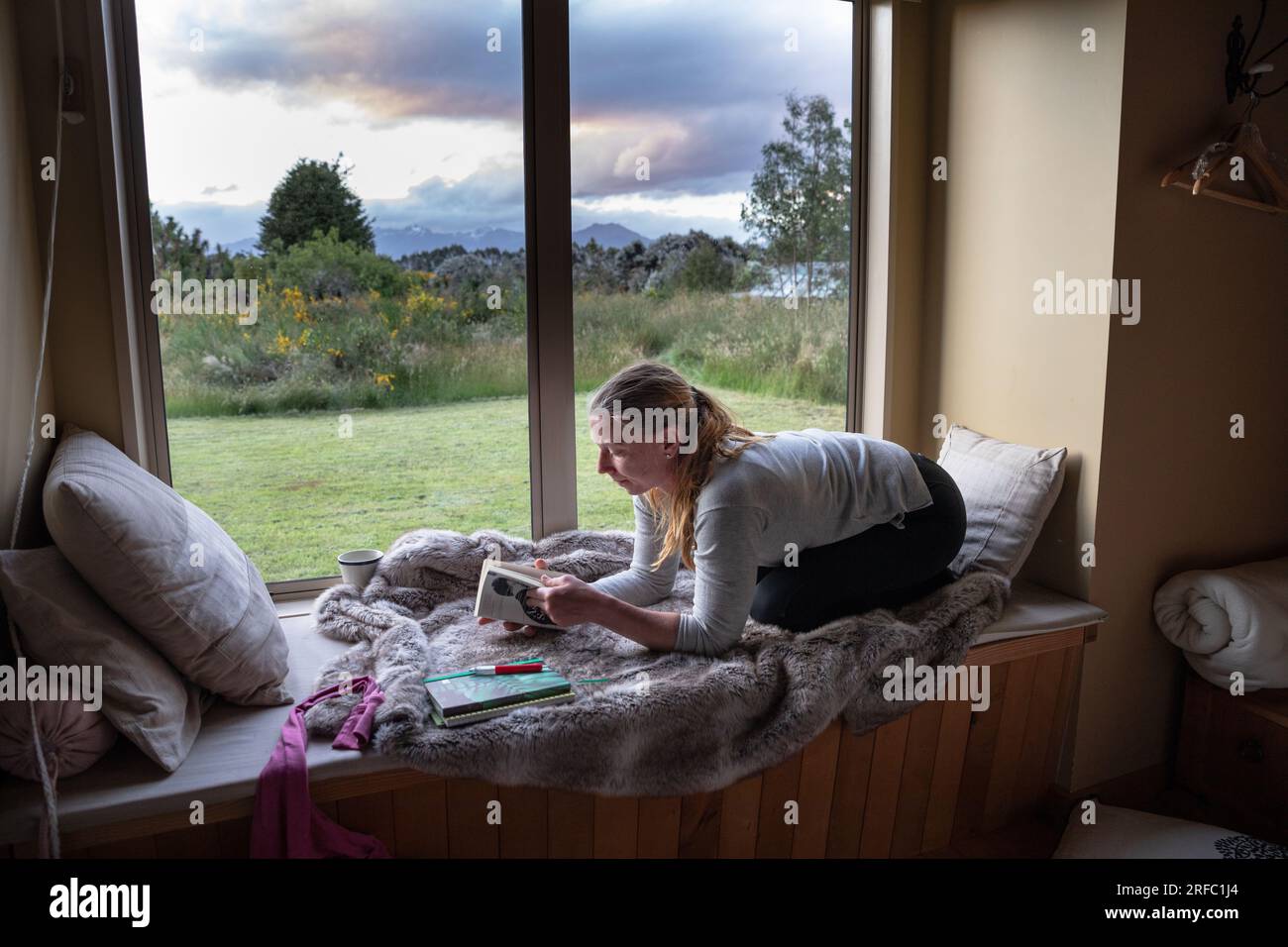 A family relax in a woodland cabin window seat in the Manapouri region ...