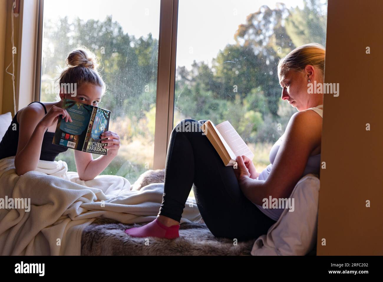 A family relax in a woodland cabin window seat in the Manapouri region ...
