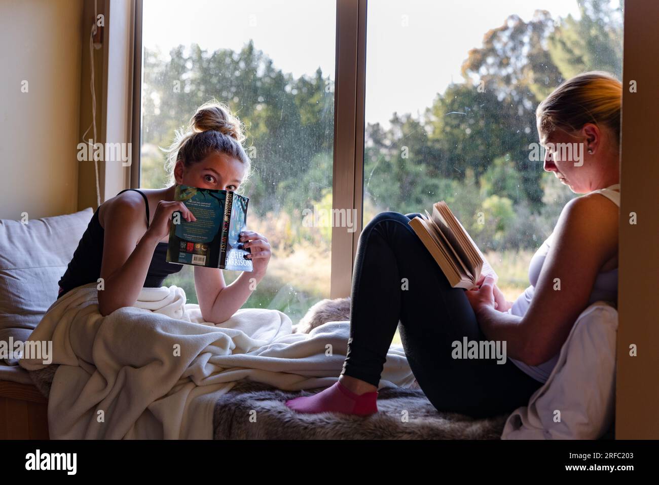 A family relax in a woodland cabin window seat in the Manapouri region ...
