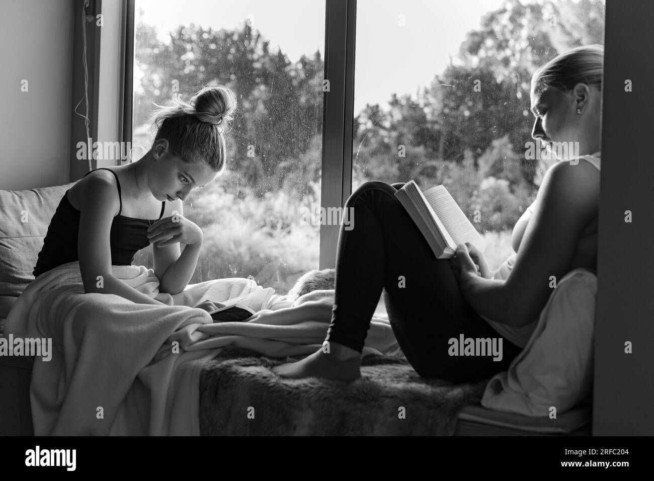 A family relax in a woodland cabin window seat in the Manapouri region ...