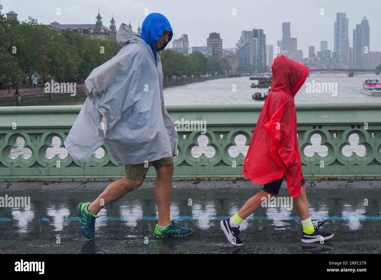 London UK. 2 August 2023 Pedestrians wearing rain ponchos on ...
