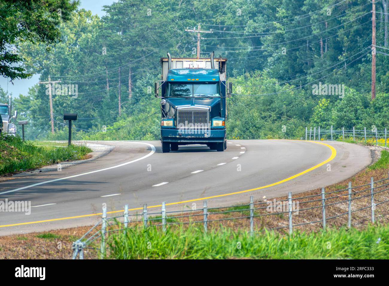 Horizontal shot of a heavy truck negotiating a curve on a rural ...