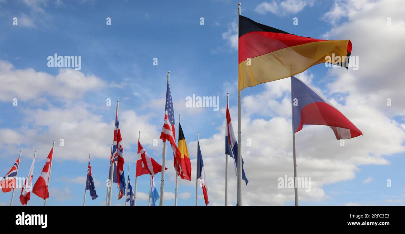 many international flags during a meeting and blue sky Stock Photo - Alamy