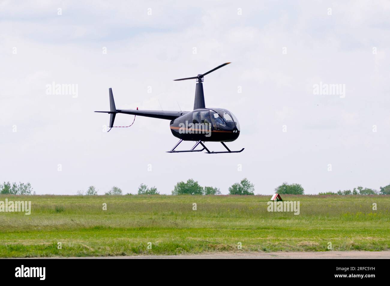 Light helicopter flying above the landing field Stock Photo - Alamy