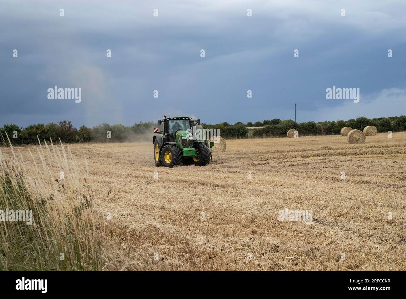 John Deere Tractor and V461M variable chamber baler producing round hay ...