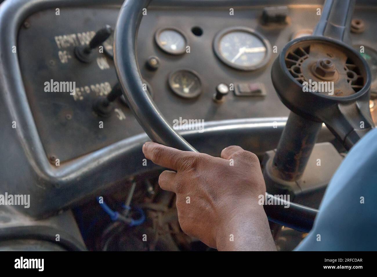 The driver's hands on the steering wheel of an old bus. Indian ...