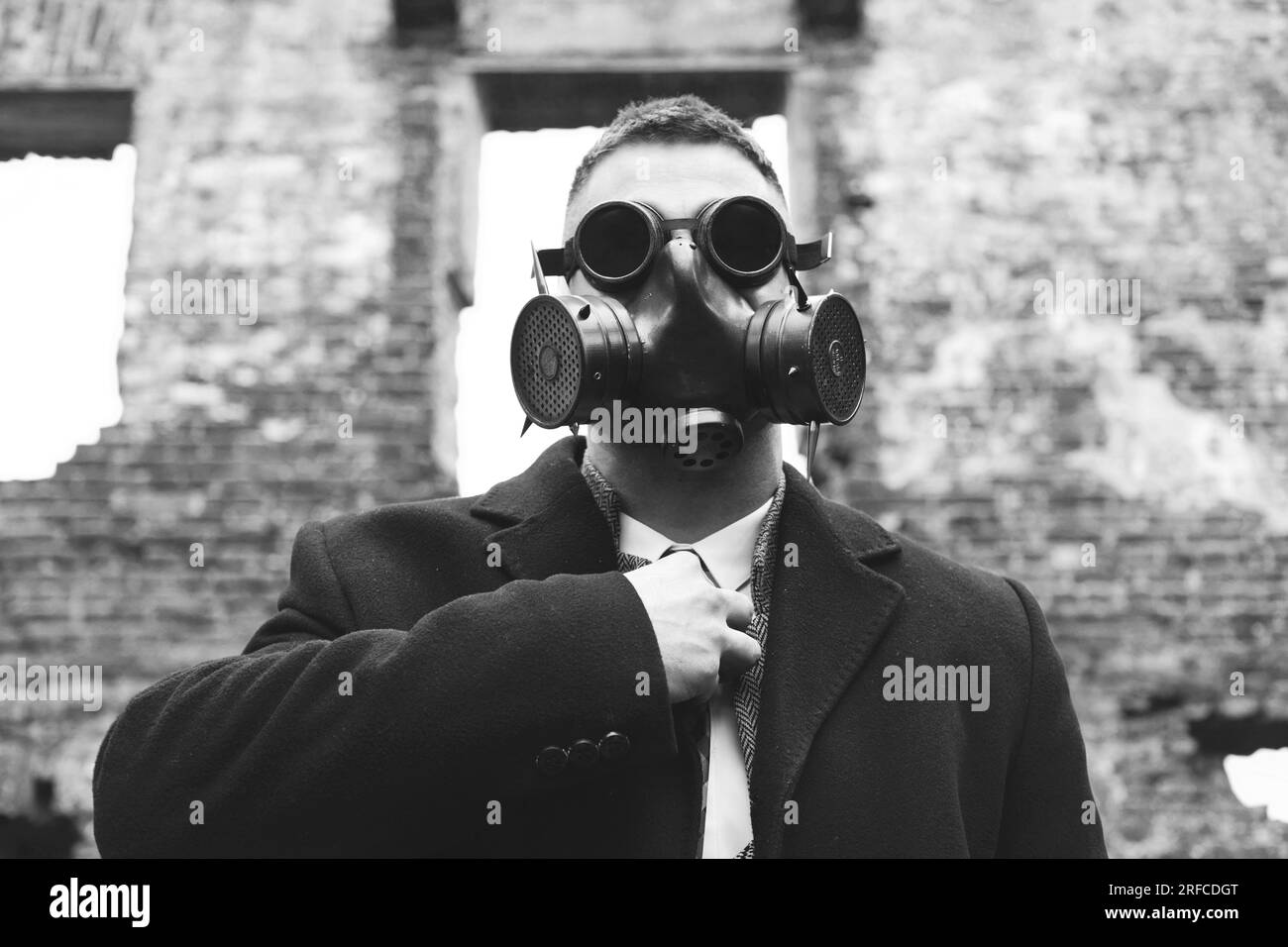 A man in a black coat, business suit, gas mask and steampunk goggles ...