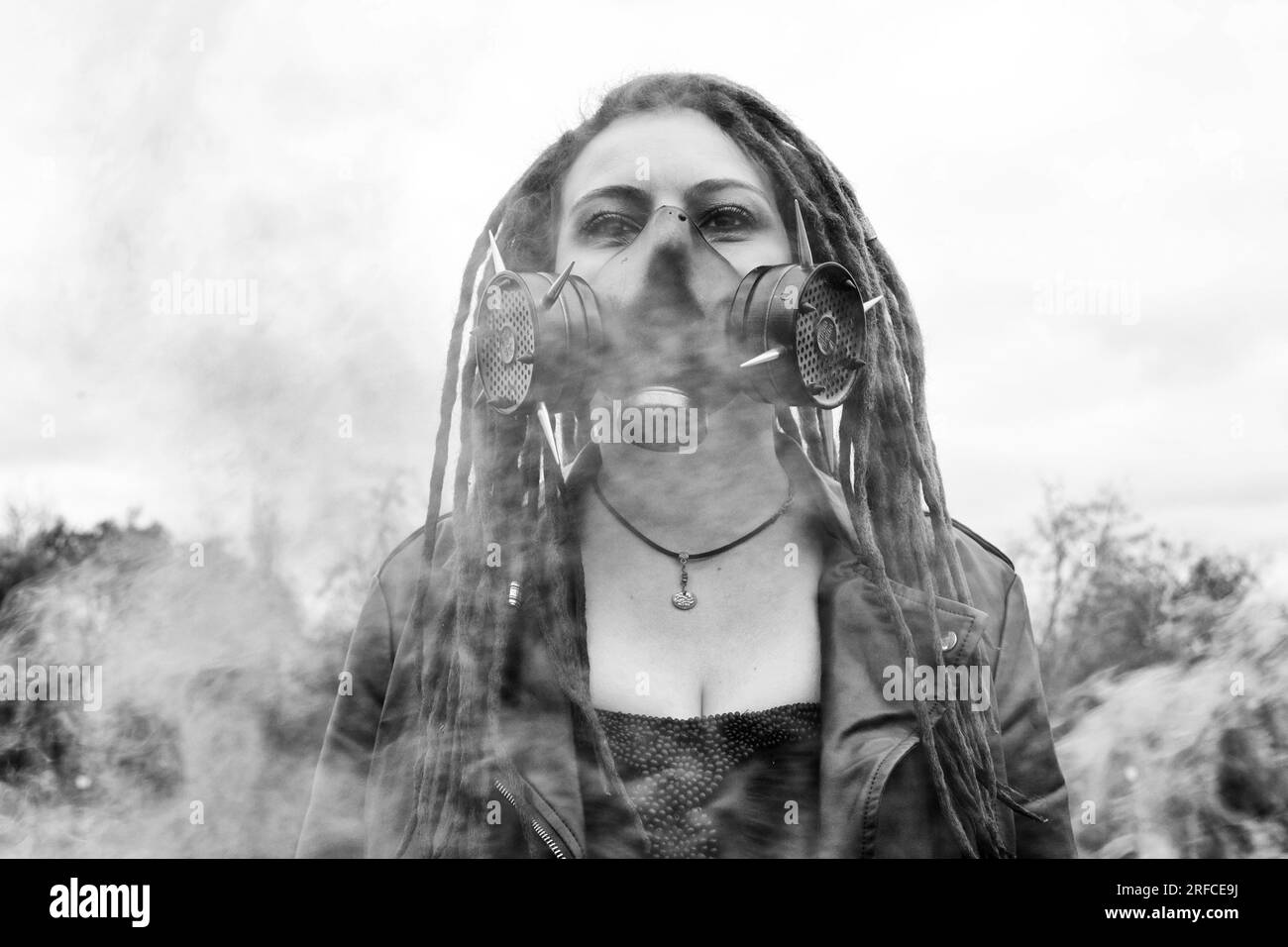 Portrait of a Woman in a jacket and dreadlocks in a gas mask with ...