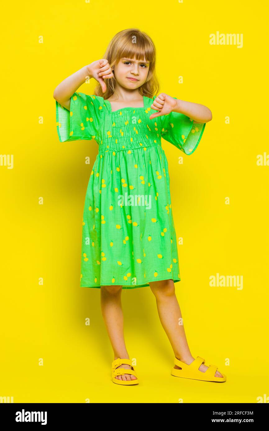 Dislike. Upset young preteen child girl kid showing thumbs down sign ...