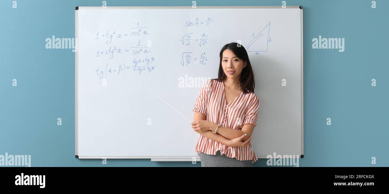 Asian math teacher near flipboard in classroom Stock Photo - Alamy