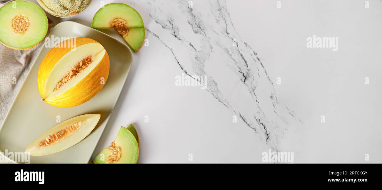 Different sweet cut melons on light marble background with space for ...