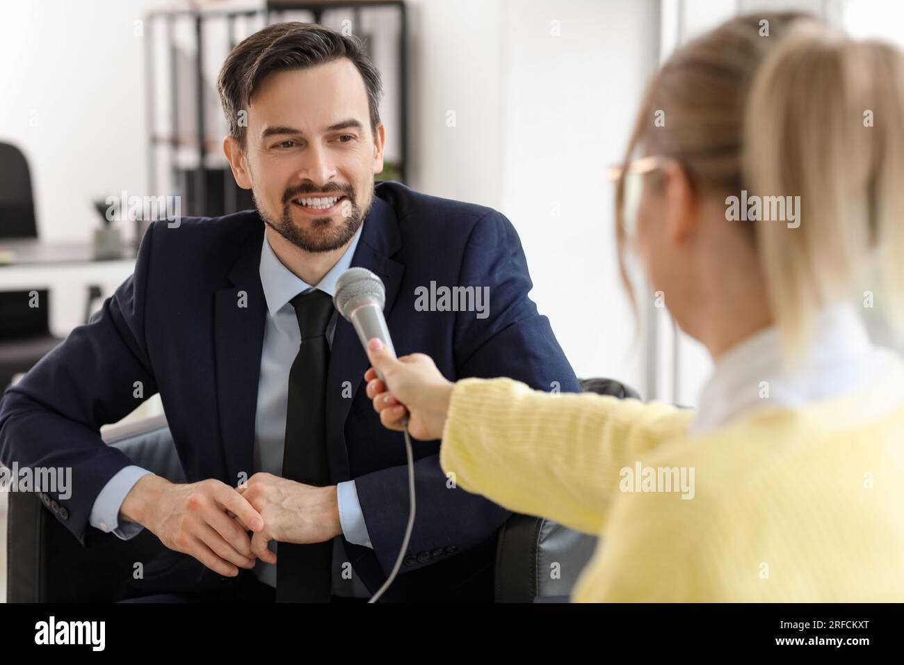 Female journalist with microphone having an interview with man in ...