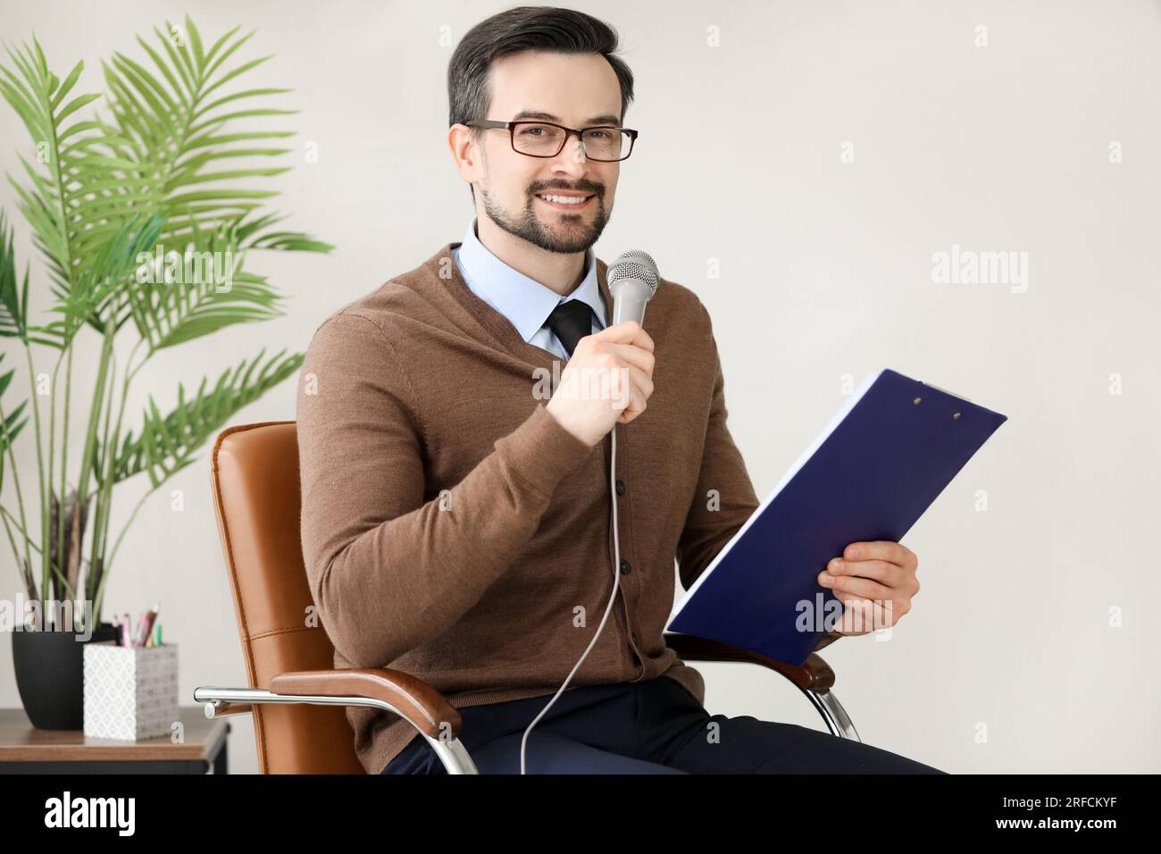 Male journalist with microphone having an interview in studio Stock ...