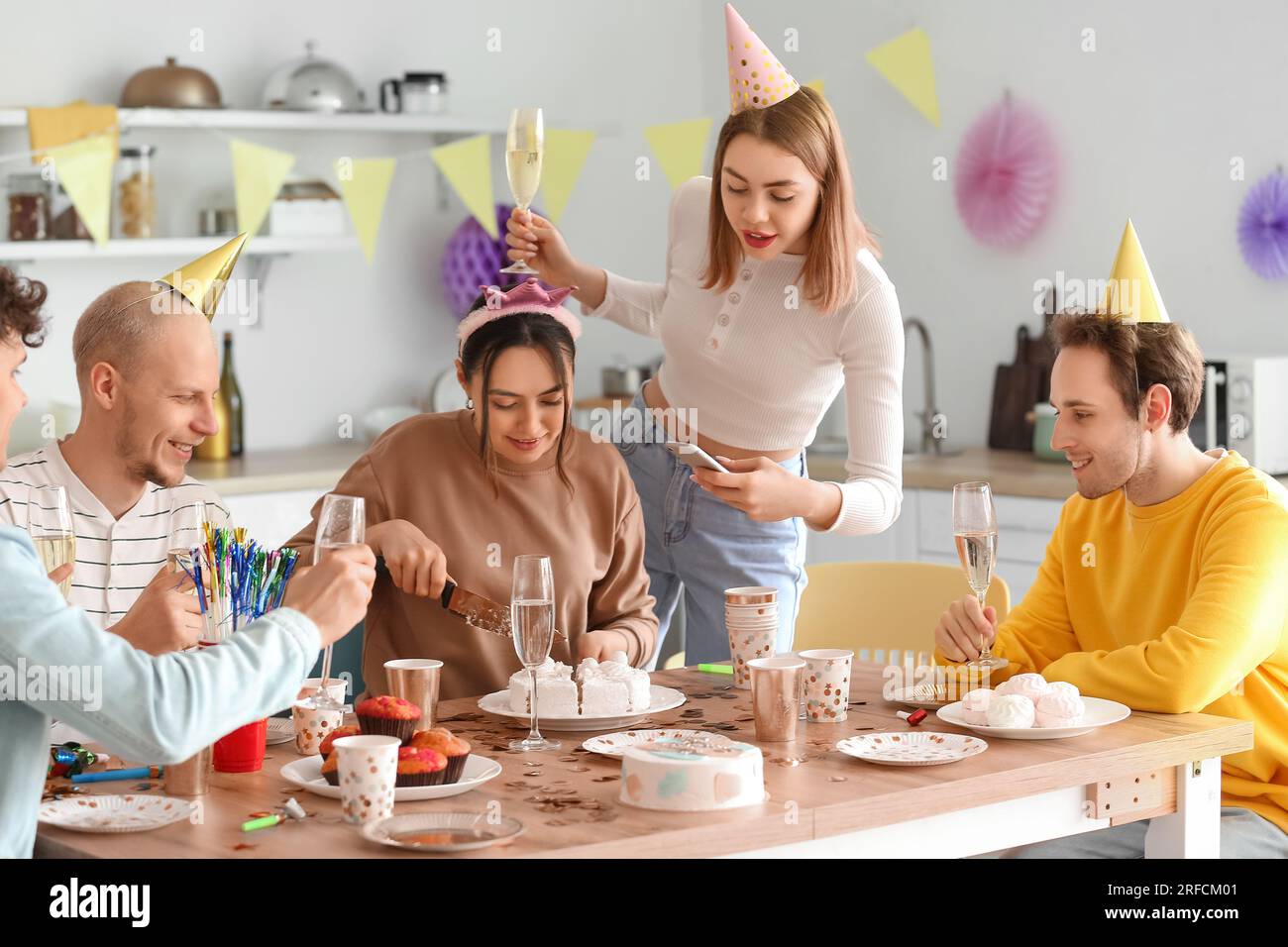Young woman cutting Birthday cake at party with her friends Stock Photo ...
