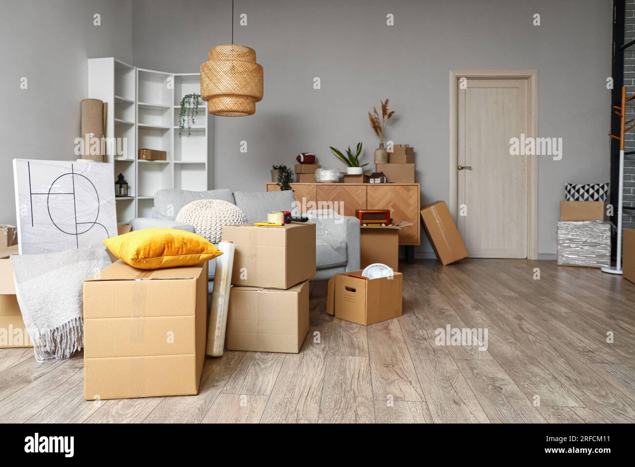 Cardboard boxes with things and sofa in living room on moving day Stock ...