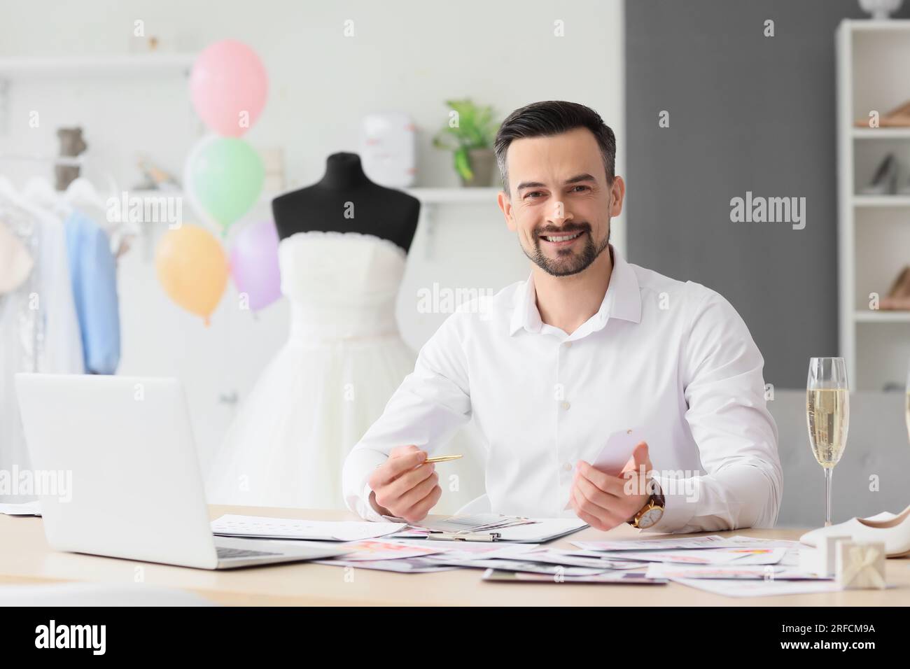 Male wedding planner working with color palettes at table in office ...