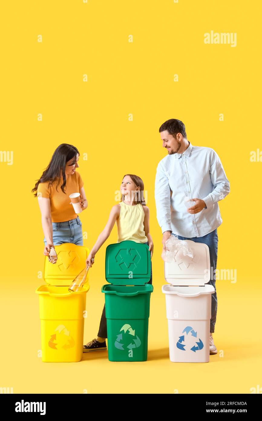 Family sorting garbage in recycle bins on yellow background Stock Photo ...