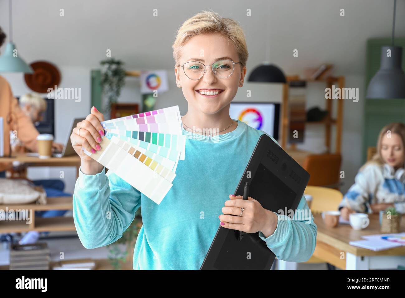 Female graphic designer with tablet and color palettes in office Stock ...