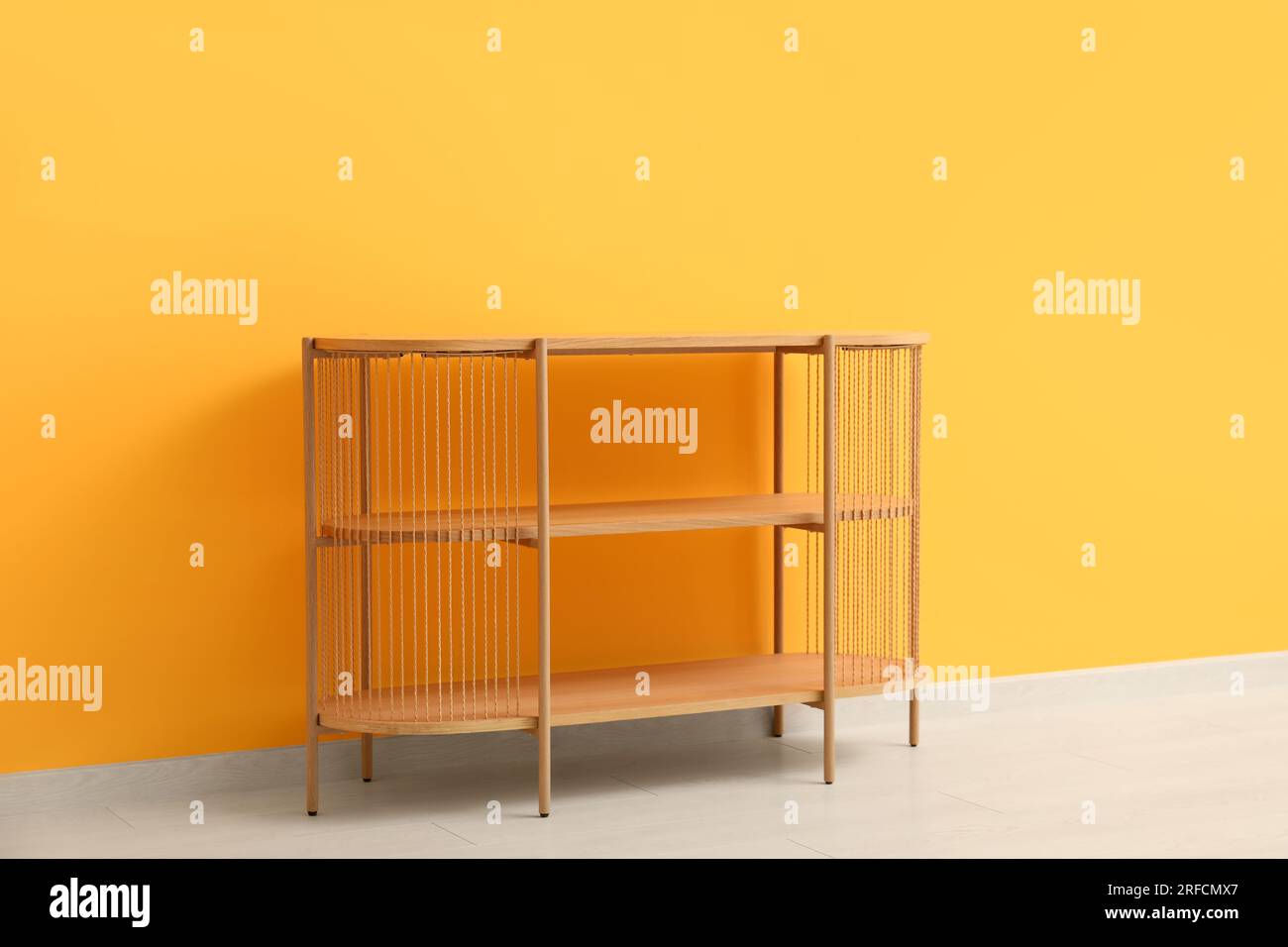 Wooden shelving unit near orange wall in room Stock Photo - Alamy