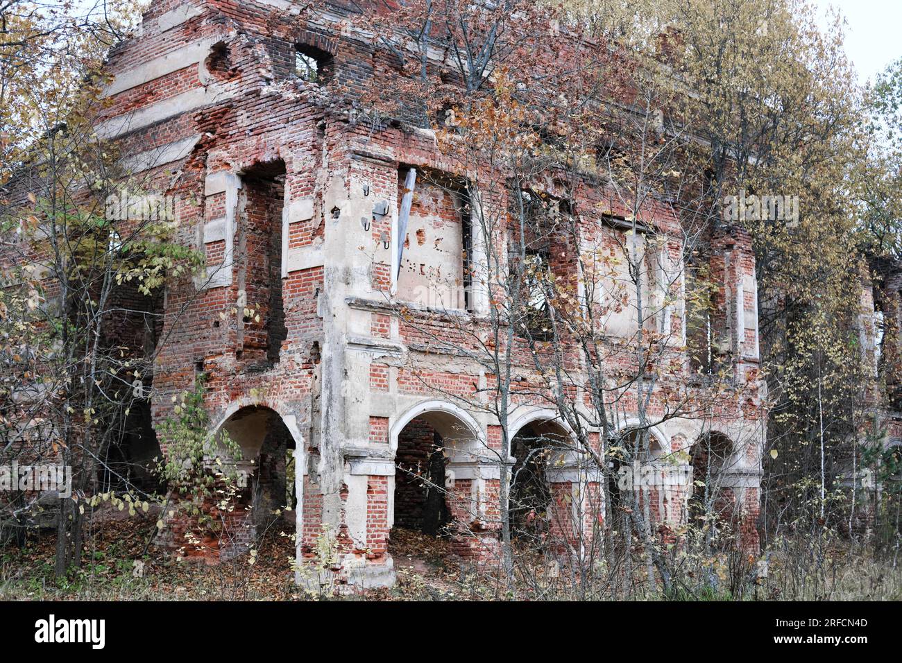 Old ruined brick building with arches in the autumn forest. Building ...