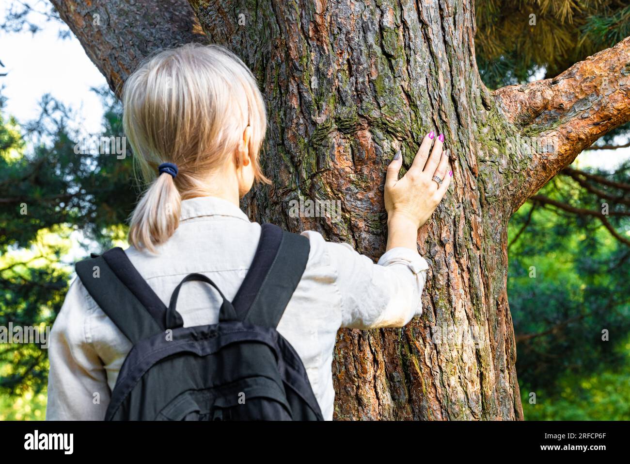 Moscow, Russia - July 03, 2023: the girl put her hand on a thick branch ...