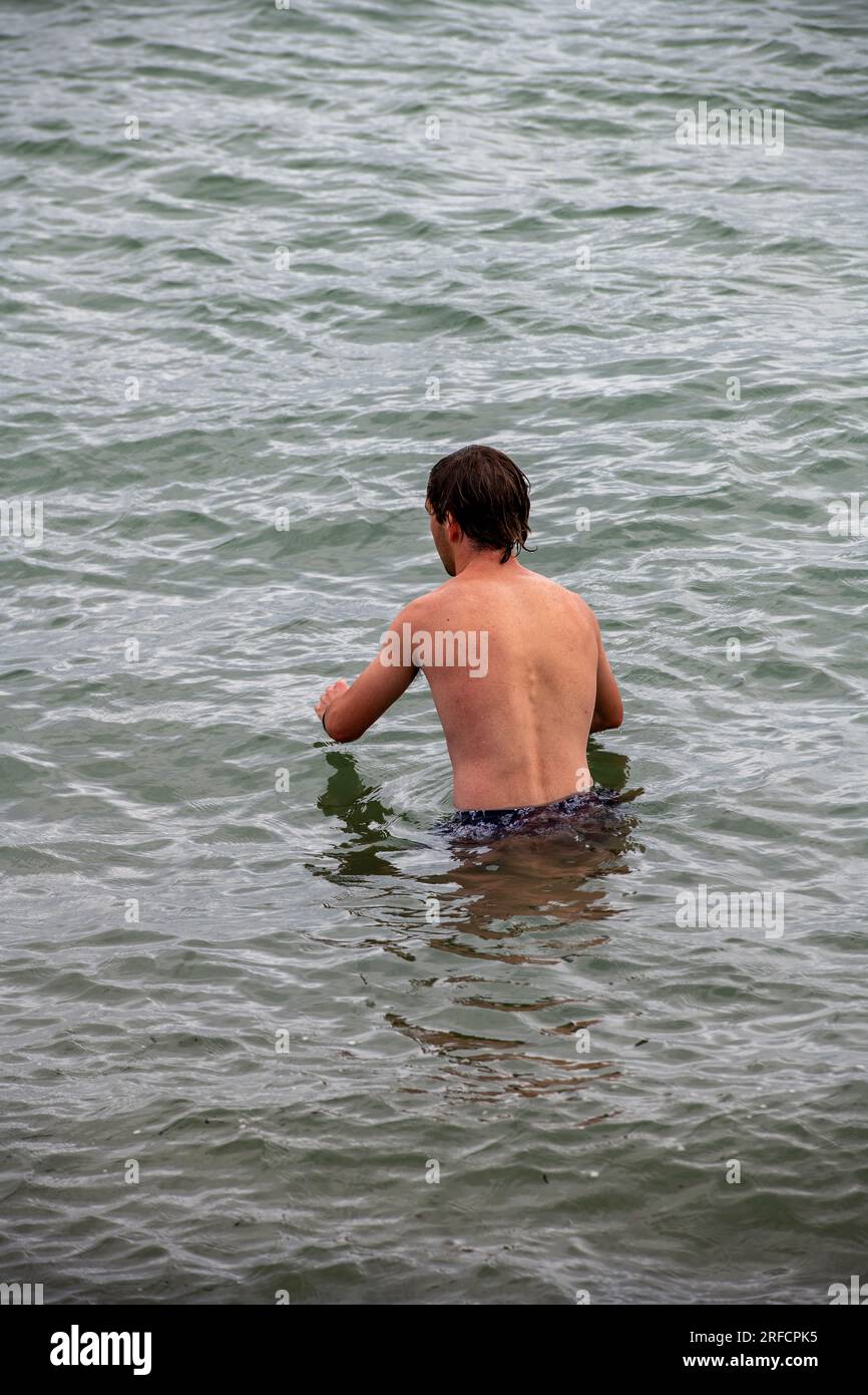 man swimming in cold water. cold water bathing. wild swimmer. wild ...