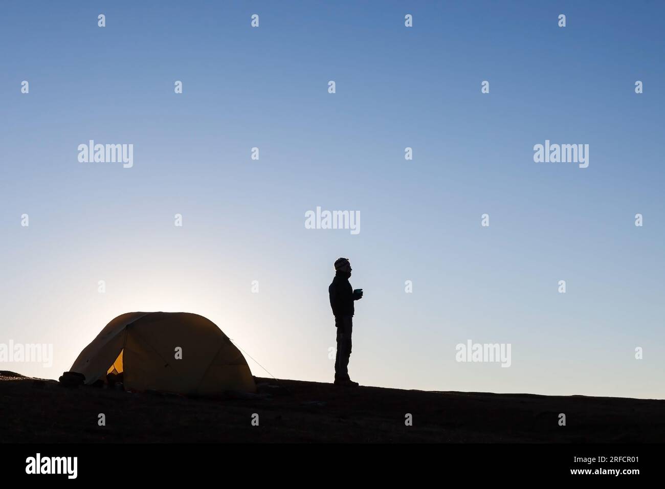 Camping silhouette of a tent and a girl in high Himalayan mountains in ...
