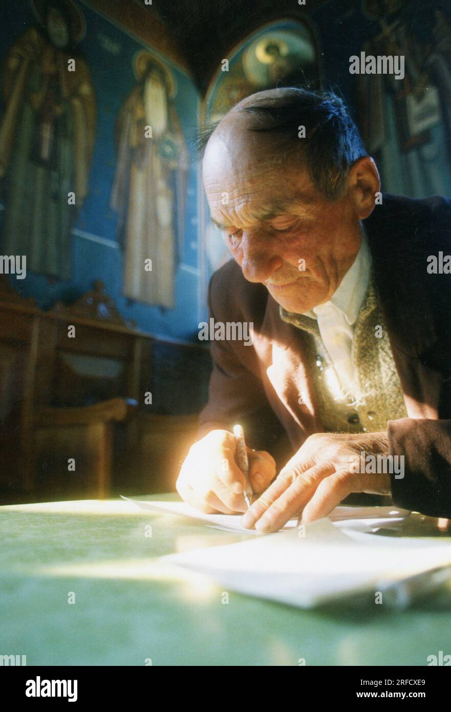 Neamt County, Romania, 1999. Man inside a church writing a "pomelnic ...