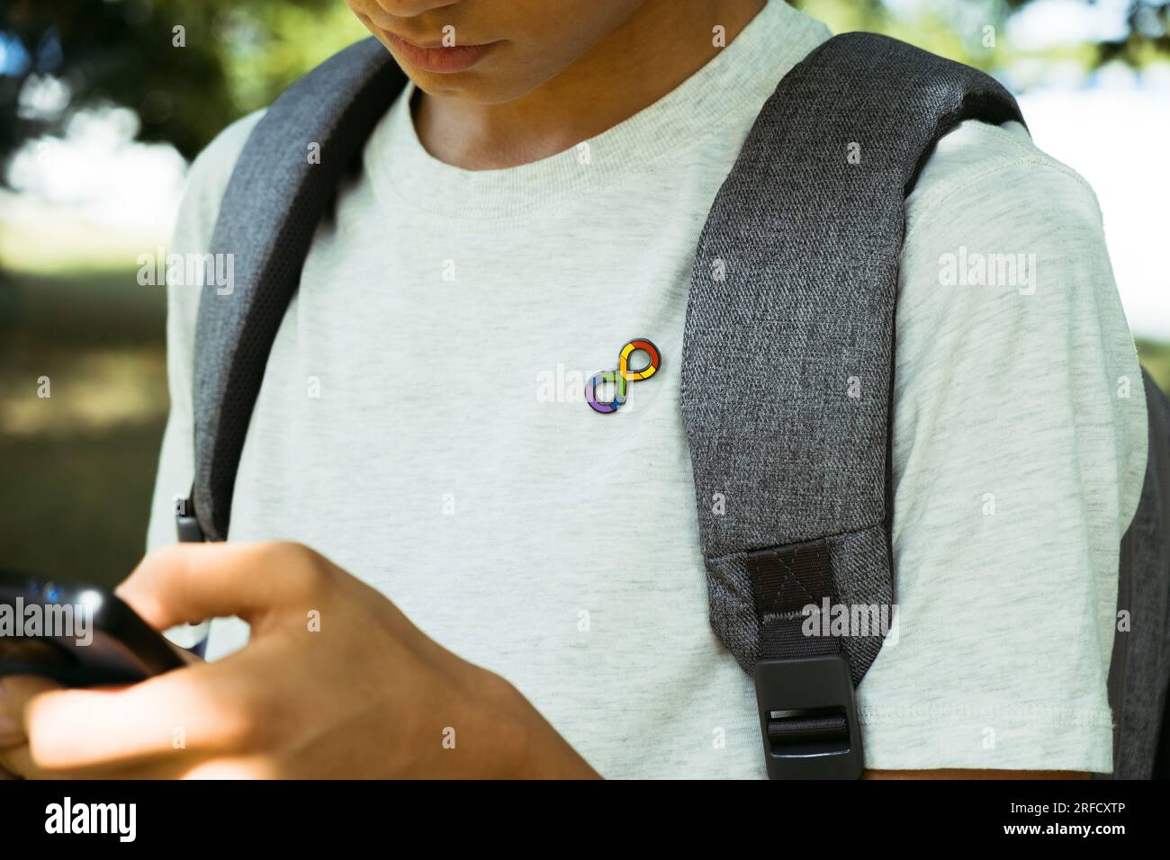 Teenage boy with autism infinity rainbow symbol sign using smartphone ...
