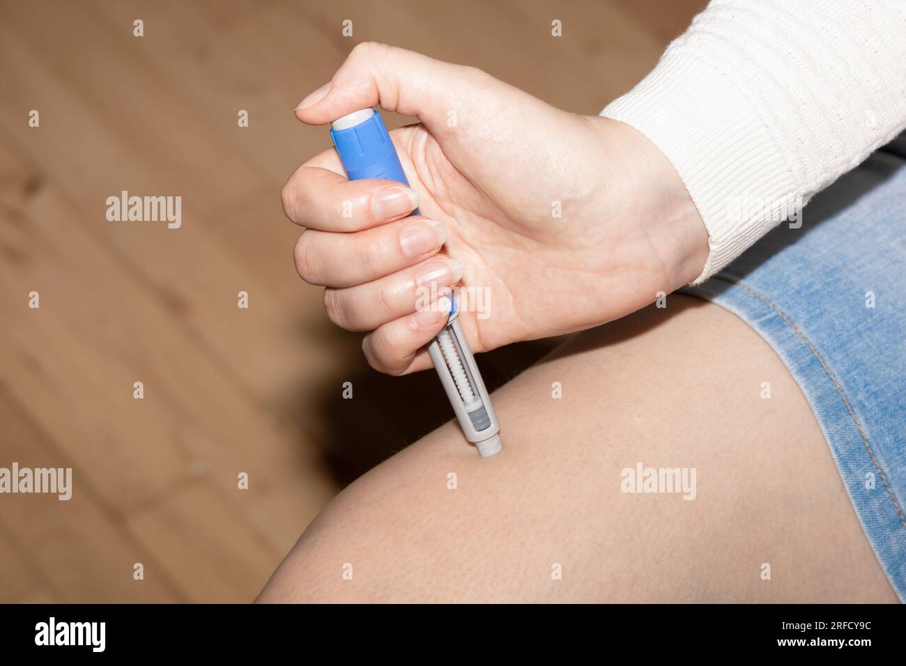 A woman injects insulin into her leg. Insulin injection pen or insulin ...