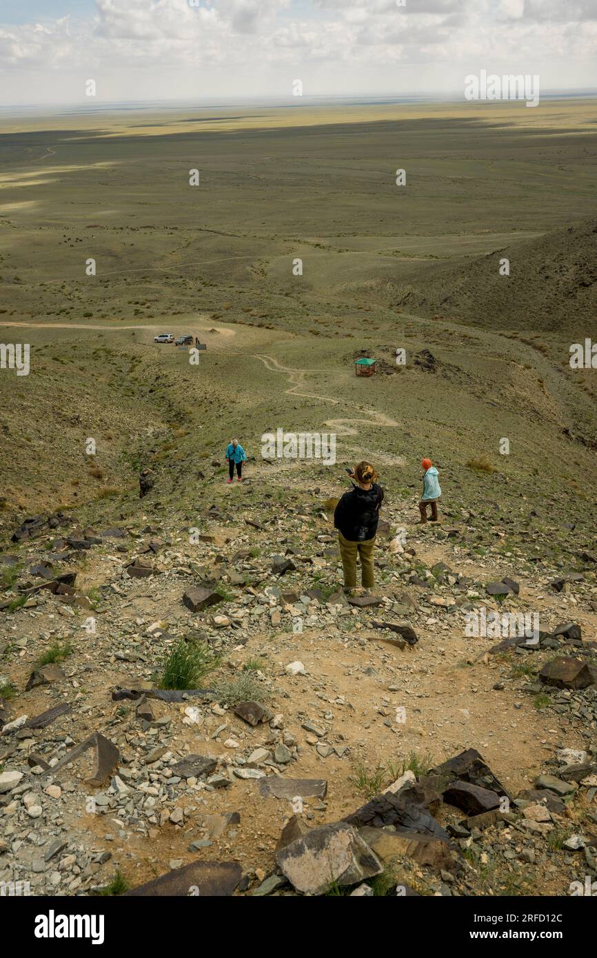 Tourists on the rocky trail to the Khavtsgait Petroglyphs dating from ...