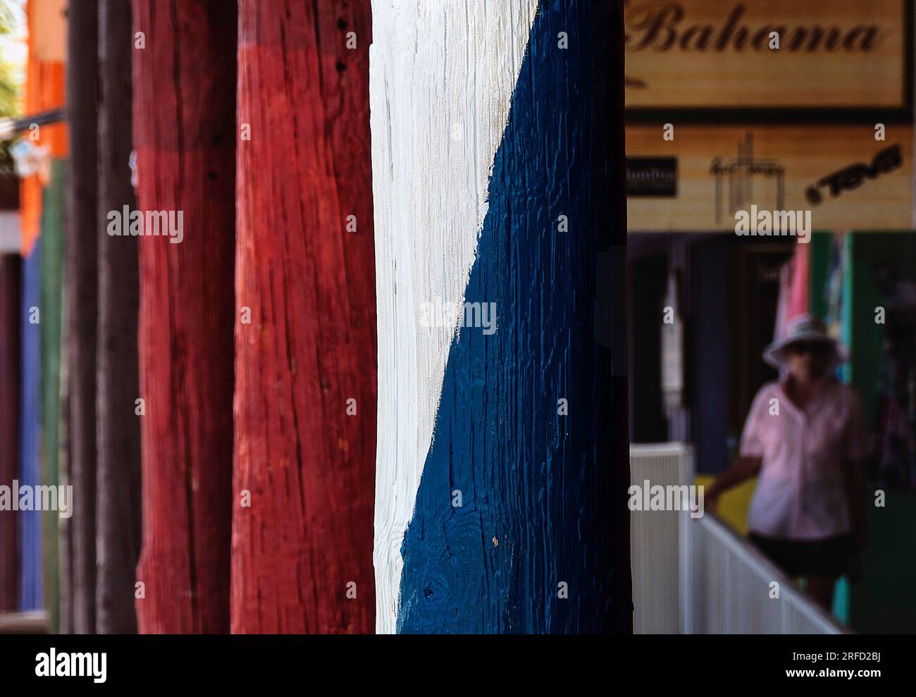 Brightly painted wooden poles in a row Stock Photo - Alamy