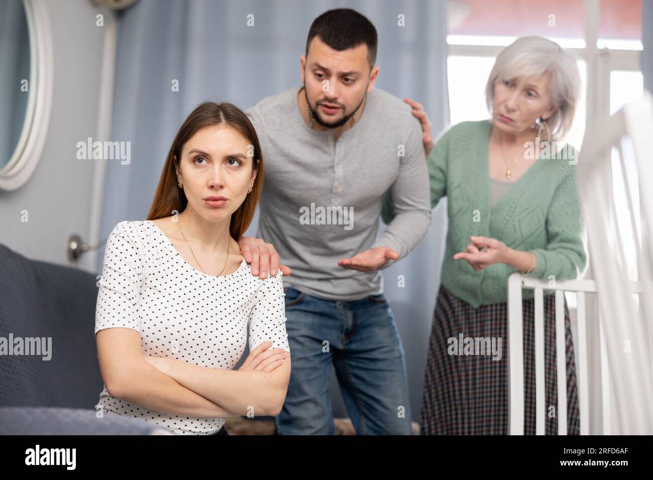 Domestic quarrel - husband and mother try to calm crying wife Stock ...