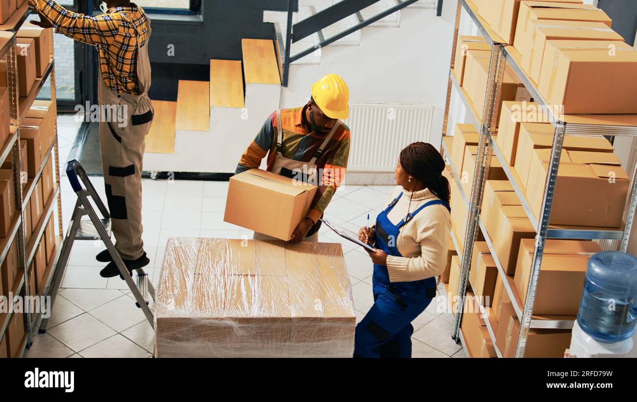 Group of people working on stock logistics in depot, organizing pallets ...