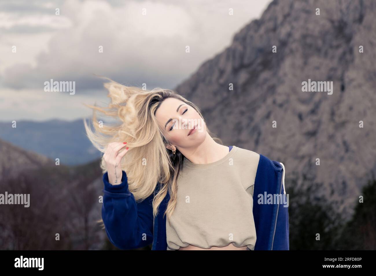 Blonde Beauty Embracing Nature: Serene Woman's Windy Mountain Moment ...