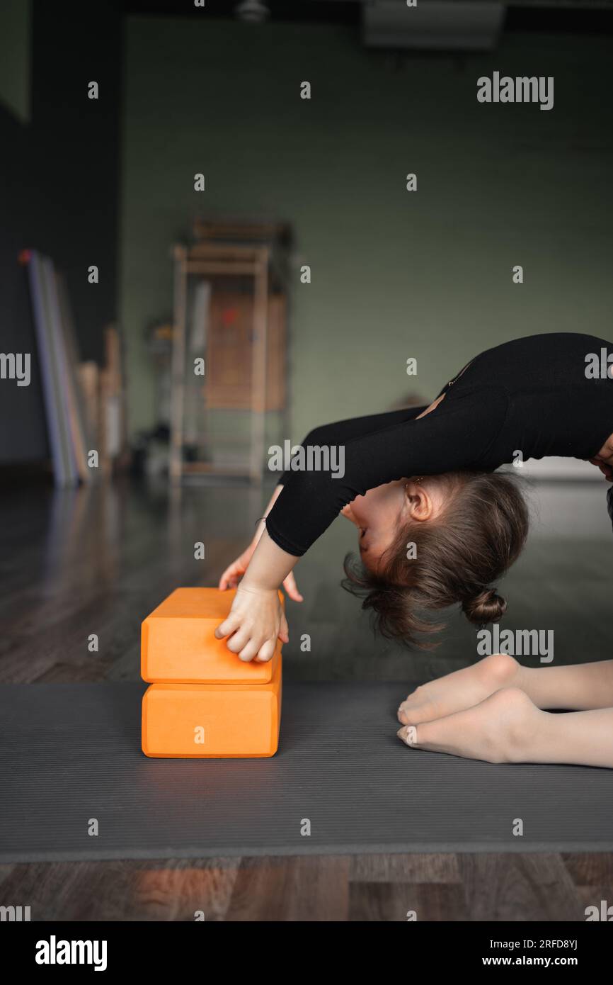 Preschool age child girl doing stretching exercises in dancing or yoga ...