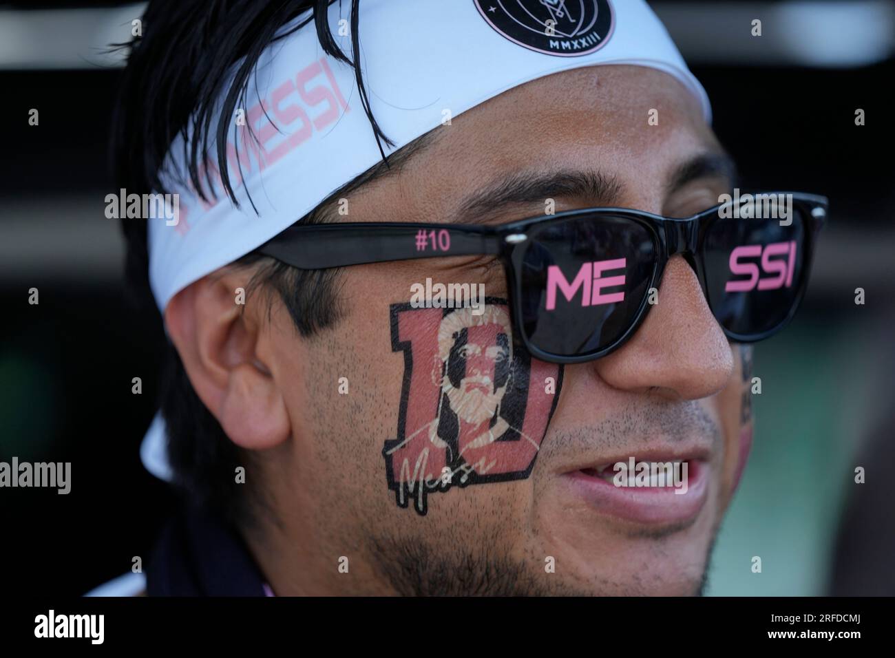 A man wears temporary tattoos supporting Lionel Messi, as fans wait for ...