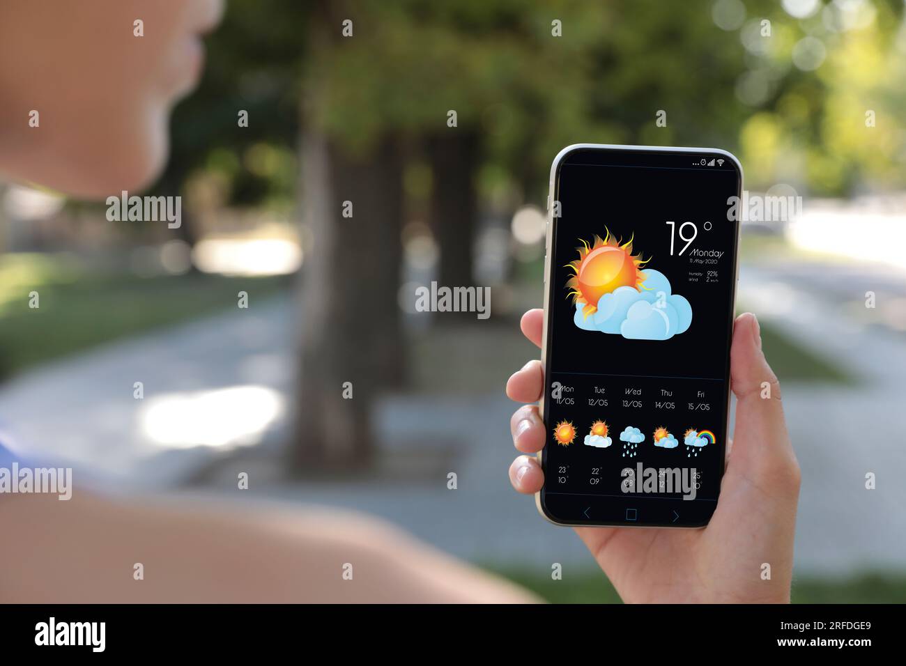 Woman checking weather using app on smartphone outdoors, closeup. Data ...