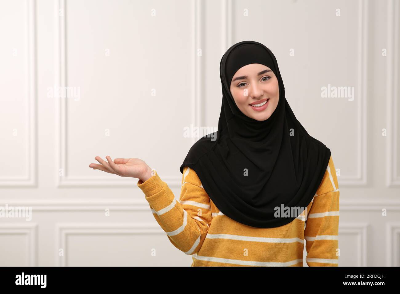 Muslim woman in hijab pointing at something indoors Stock Photo - Alamy