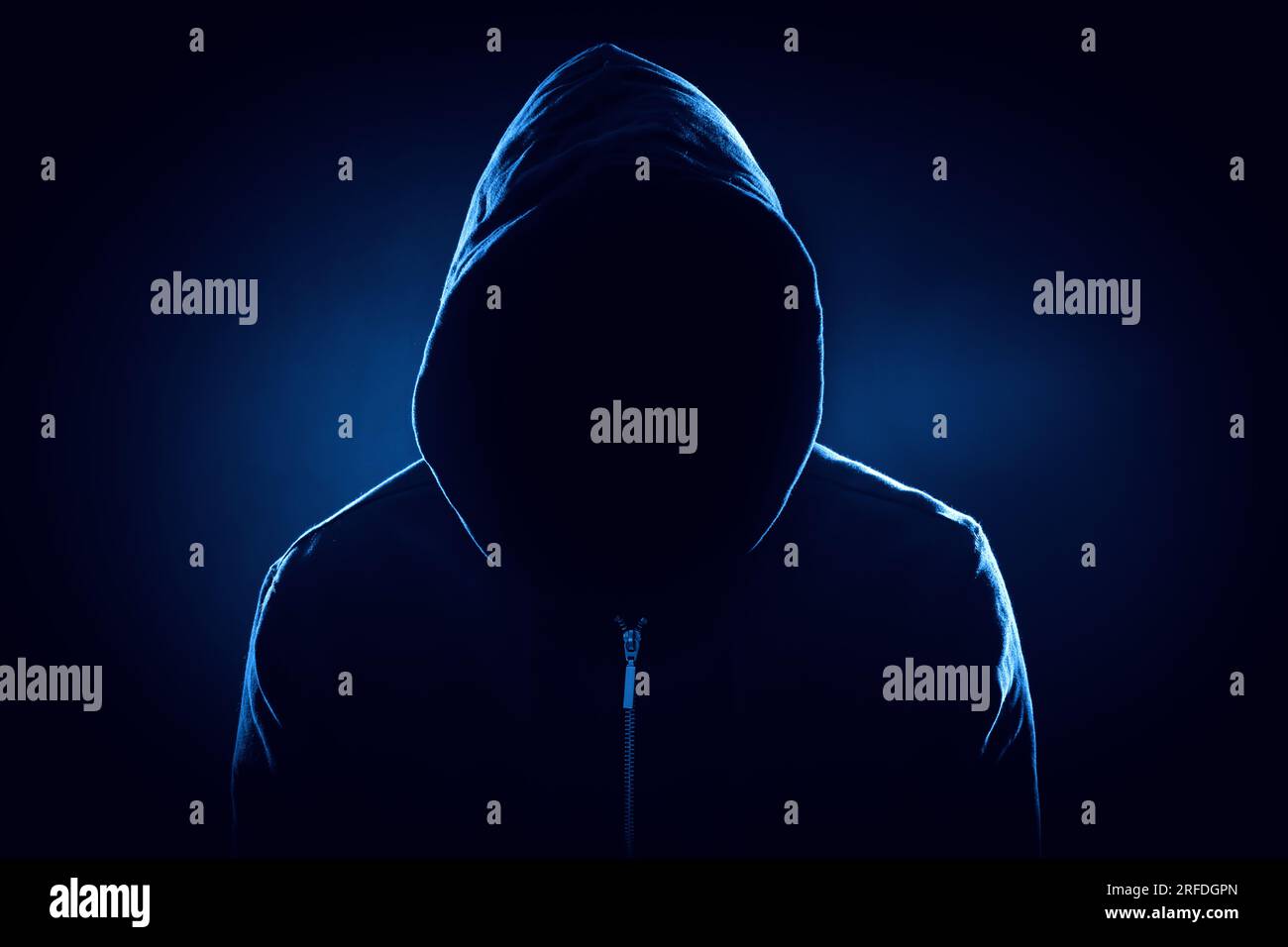 Anonymous man in hood on black background, color toned Stock Photo - Alamy