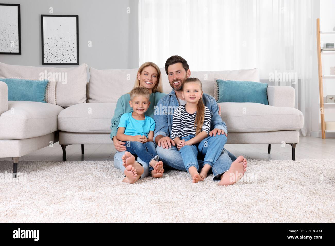 Portrait of happy family with children on soft carpet at home Stock ...