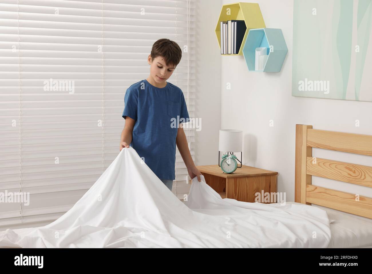 Boy changing bed linens in children room Stock Photo - Alamy