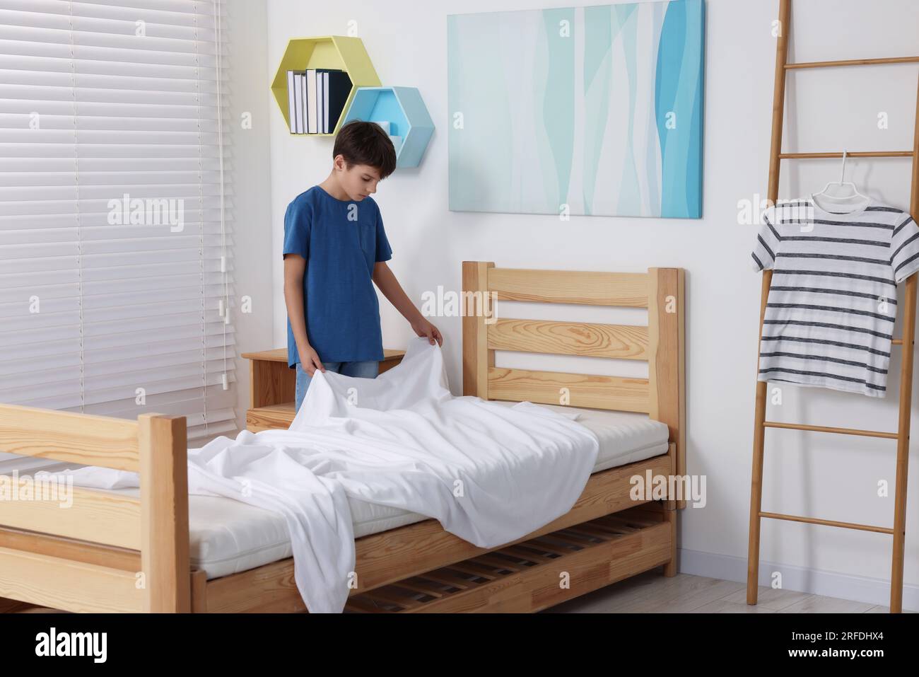 Boy changing bed linens in children room Stock Photo - Alamy
