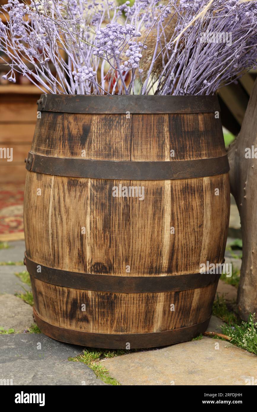 Traditional wooden barrel and beautiful decorative branches outdoors ...
