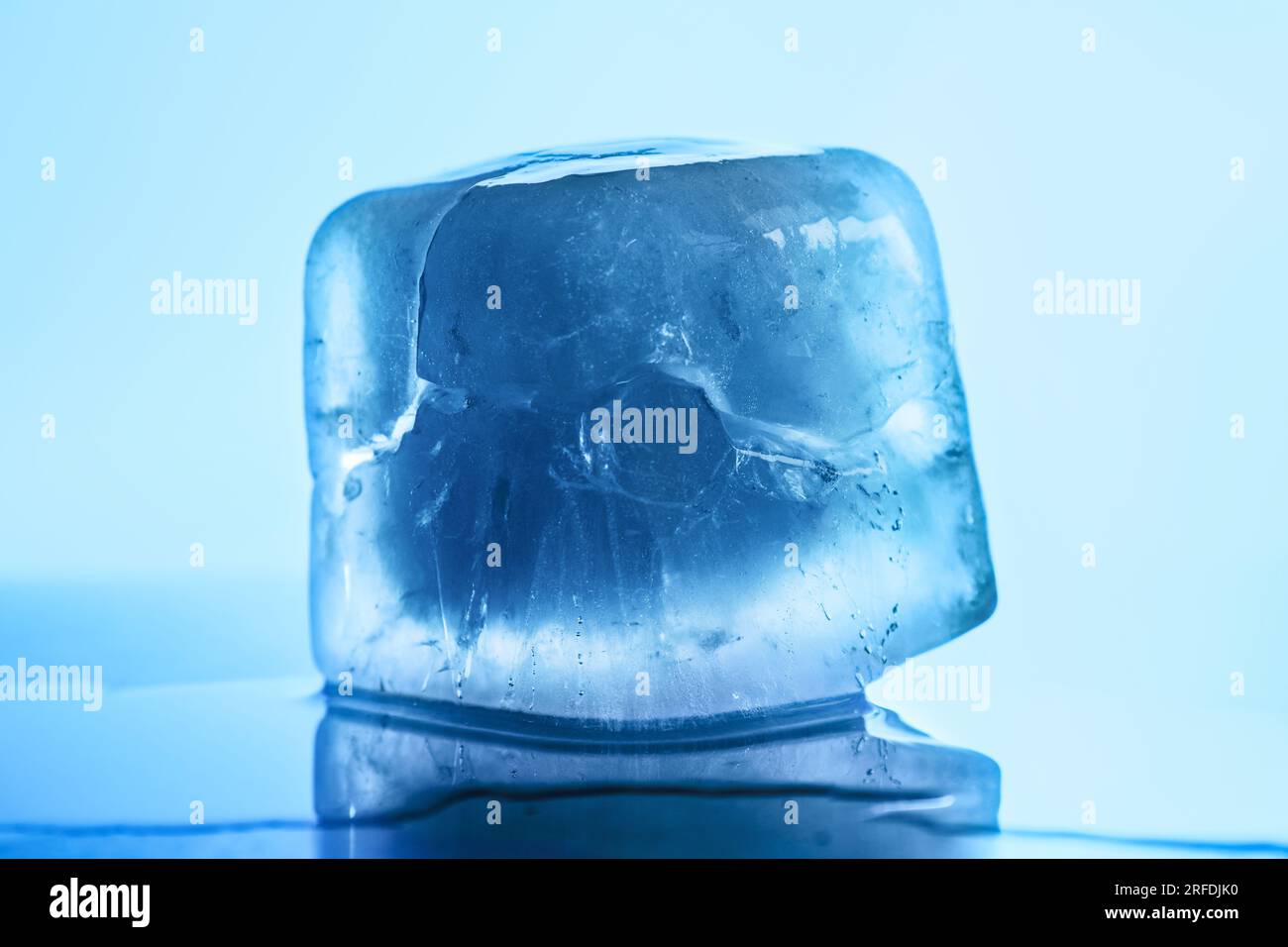 One crystal clear ice cube on light blue background, closeup. Color tone effect Stock Photo - Alamy