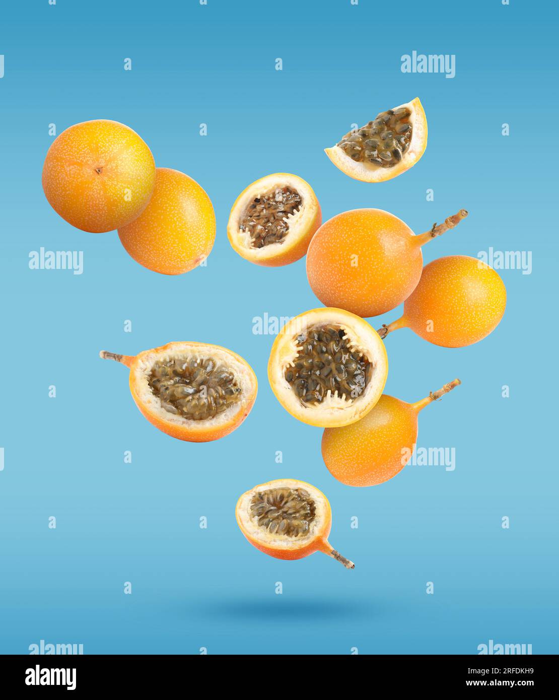 Delicious ripe granadillas falling on light blue background Stock Photo ...