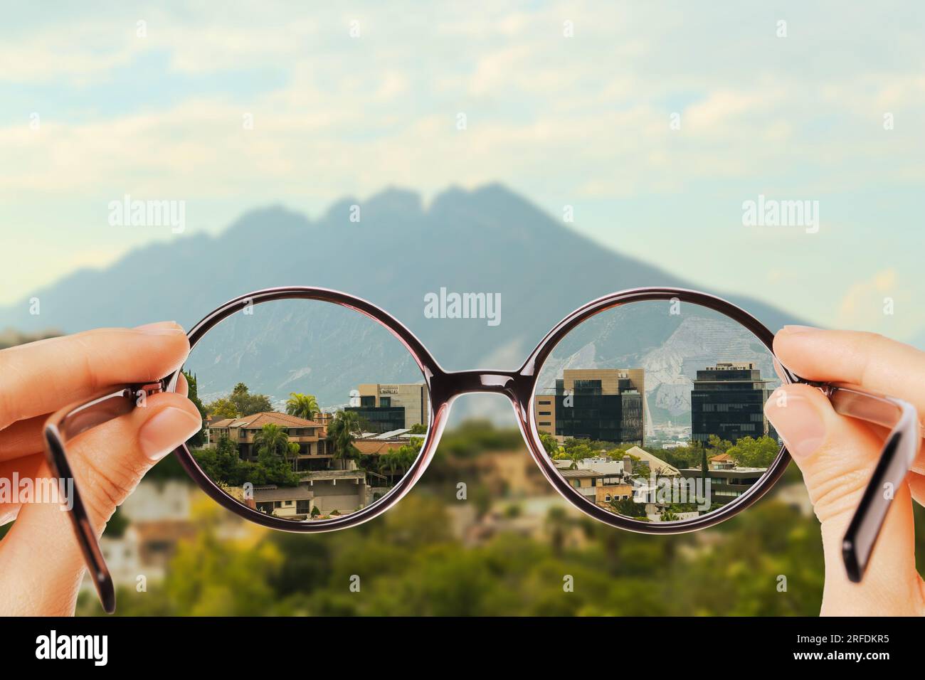 Vision correction. Woman looking through glasses and seeing landscape ...
