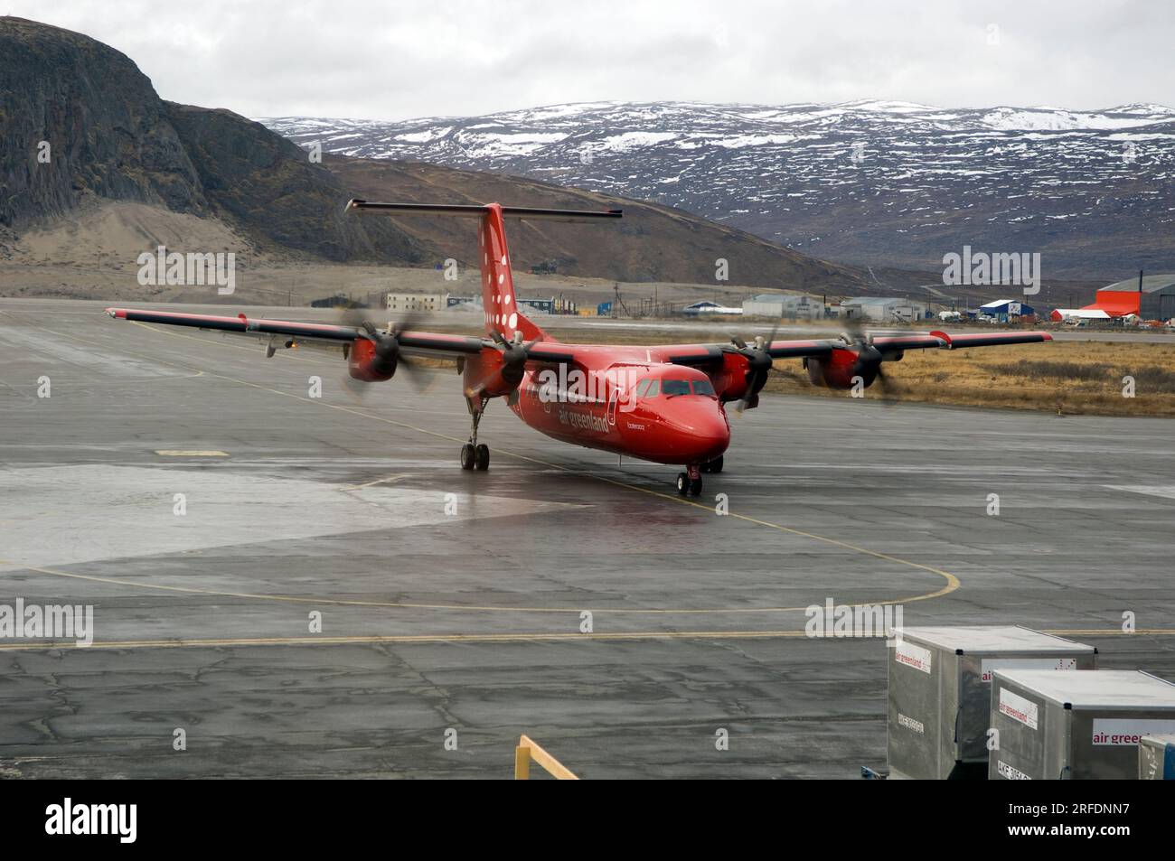 An Air Greenland pane with its propellers spinning arrving at the ...