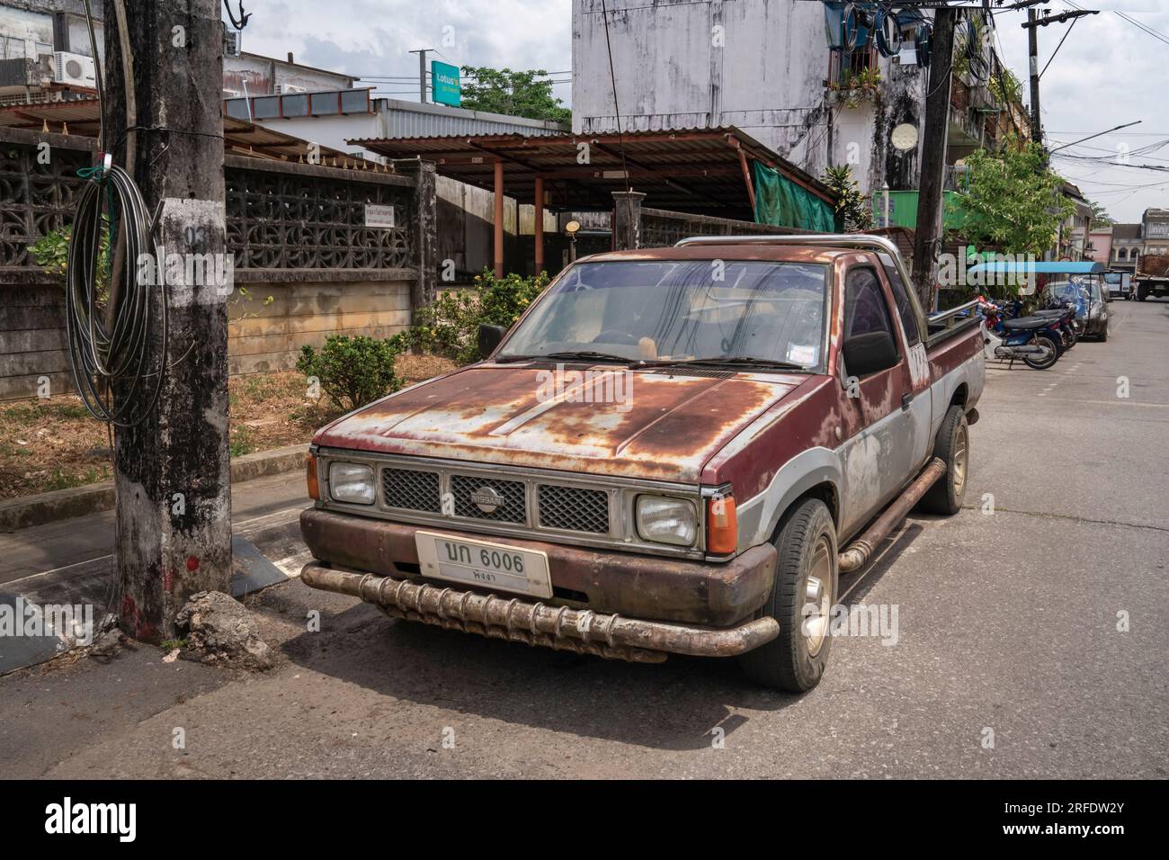 An old and rusty Nissan pickup truck on the street of the old town of ...